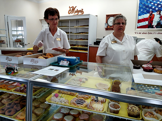 Behind every great donut is a dedicated team, carefully arranging sweet treasures that will disappear by mid-morning.