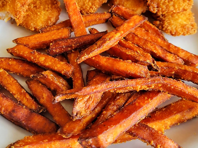Sweet potato fries with that ideal crispy exterior hiding fluffy, naturally sweet perfection inside every bite.