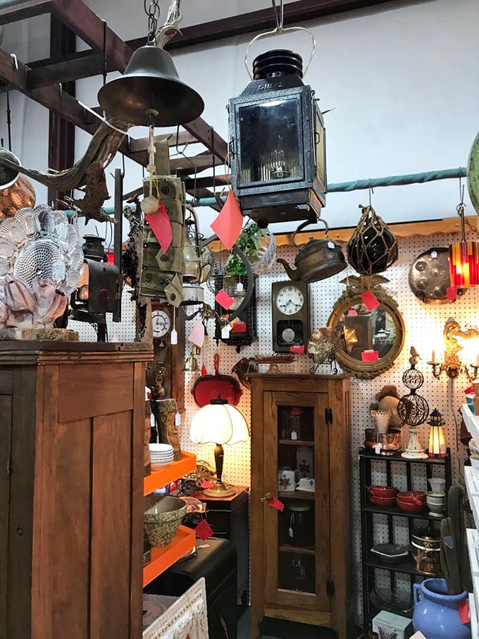 Vintage lighting creates a magical overhead display where lanterns, bells, and fixtures dangle like industrial jewelry. Edison would feel right at home here.