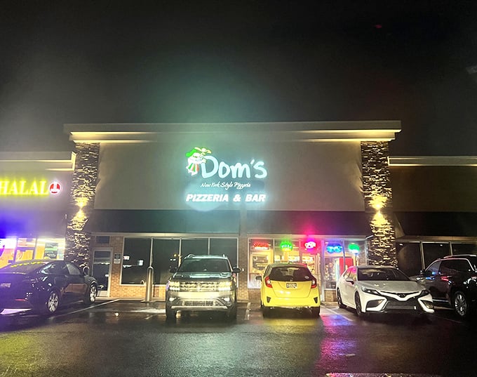 Dom's neon sign glows with late-night pizza promise. When those lights are on, pizza dreams can come true any time.