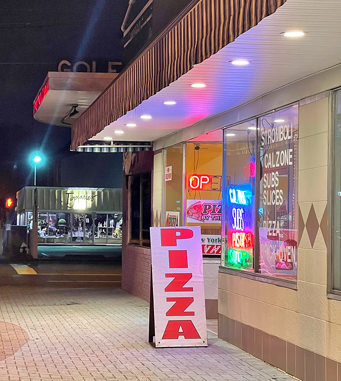 Nighttime reveals the neon glow of pizza perfection. York's storefront may be simple, but those ovens work serious magic.