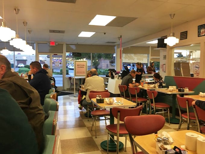 A bustling dining room where strangers become temporary neighbors, united by the universal language of "pass the syrup, please."