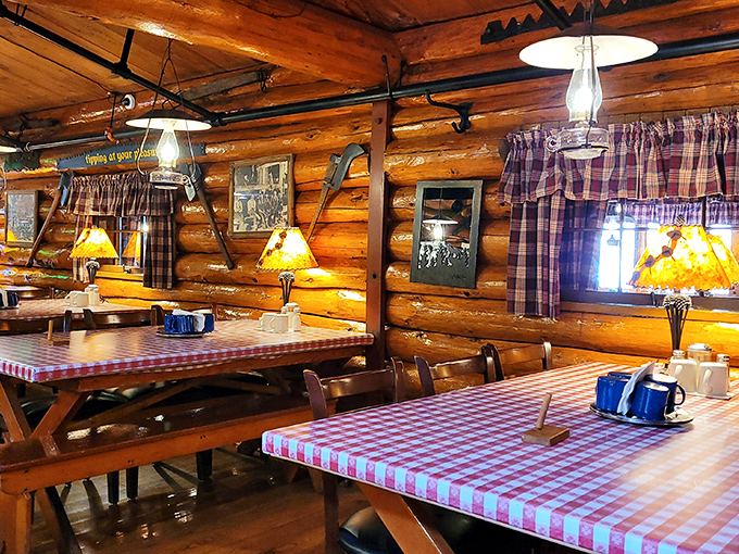 Plaid curtains, log walls, and the warm glow of lamplight create the perfect backdrop for food that tastes like childhood memories you wish you had.