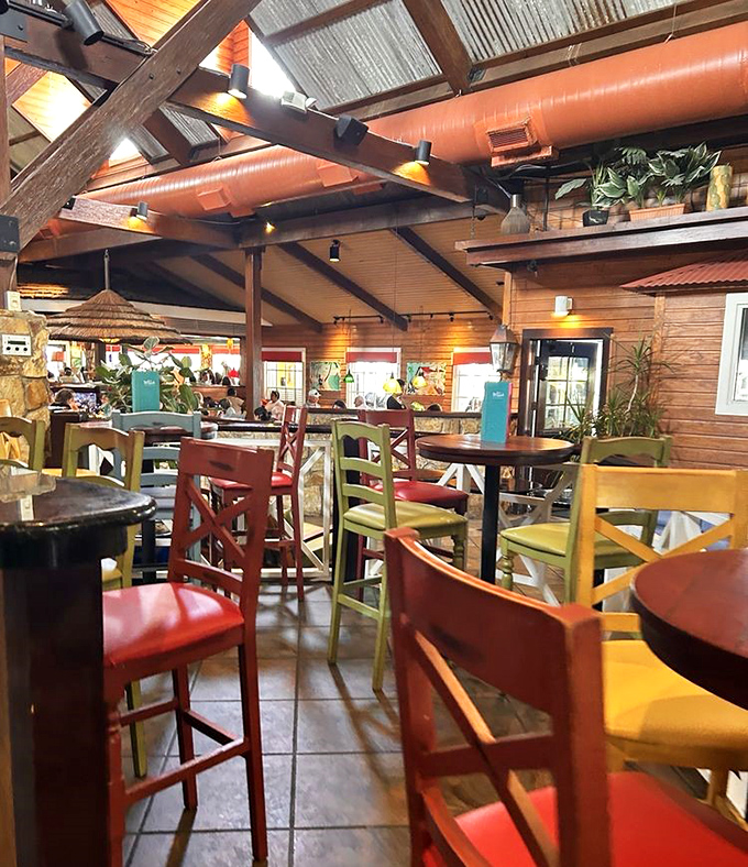 Rustic wooden beams, colorful chairs, and warm lighting create the perfect backdrop for that moment when you realize you're definitely ordering dessert.