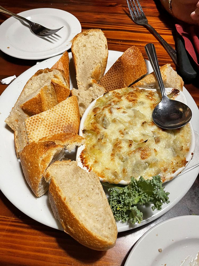 Artichoke dip that demands to be scooped with crusty bread until the plate is embarrassingly clean. The kind of appetizer that makes you reconsider your main course order.