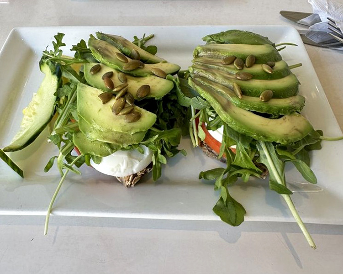 Avocado toast gets the Swedish treatment with perfect green slices fanned out like a hand of winning cards. Those pumpkin seeds are the royal flush.