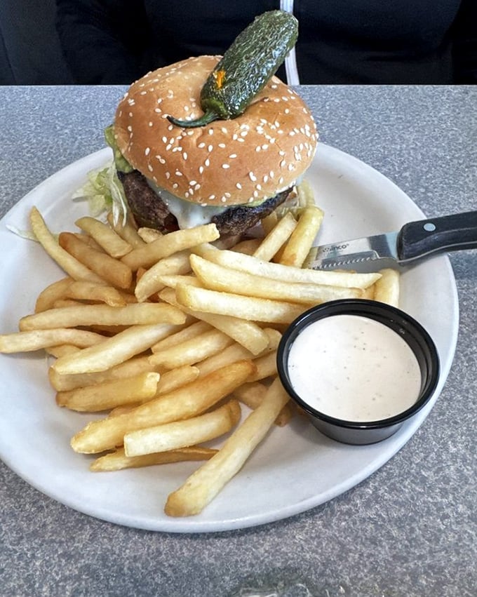 A burger topped with a jalape&ntilde;o that stands guard like it's protecting treasure. And with fries this golden, it absolutely is.