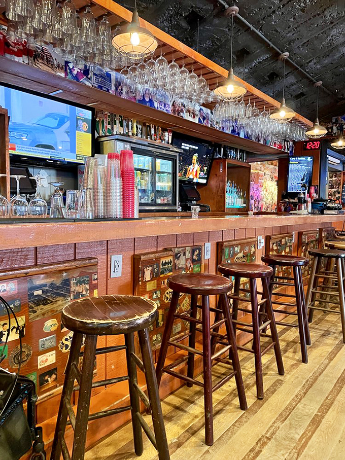 The bar's wooden patina tells stories of countless toasts and celebrations, where hanging glassware catches light like chandeliers in this cathedral of conviviality. 