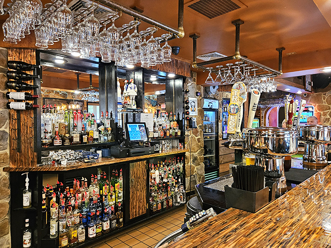 A bar stocked with enough spirits to satisfy any request. The hanging glassware catches light like crystal chandeliers.