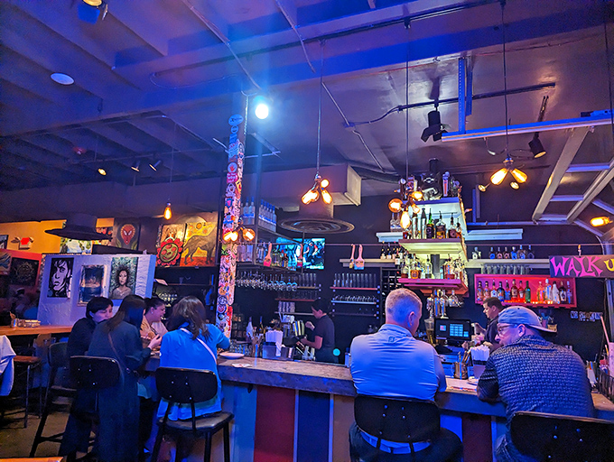 The bar area hums with energy as patrons gather under colorful lights, proving that art appreciation pairs perfectly with a good cocktail.
