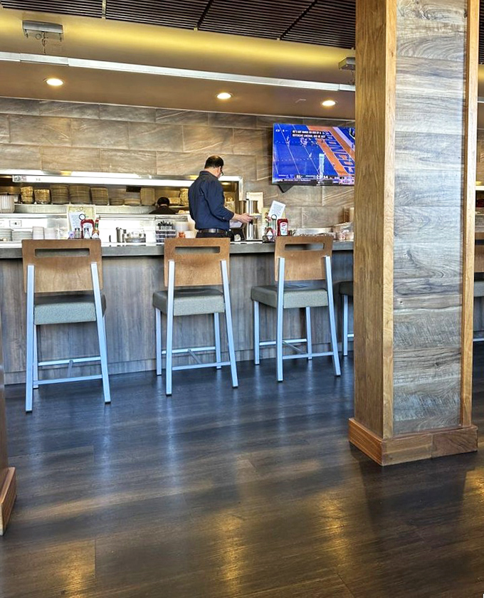 The bar area glows with promise &ndash; where diner comfort meets cocktail hour sophistication in perfect harmony. 