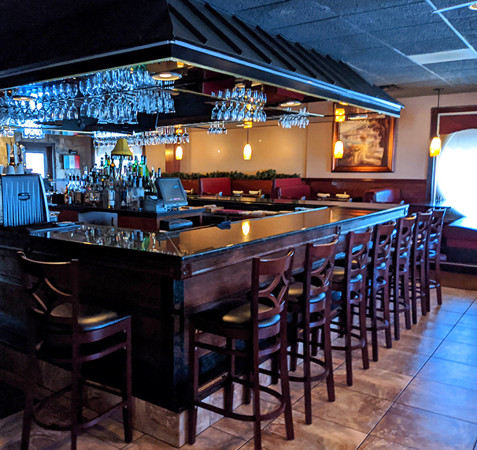 Gleaming glassware hangs like crystal stalactites above a bar that's equally ready for celebration or consolation, depending on what your day demands.