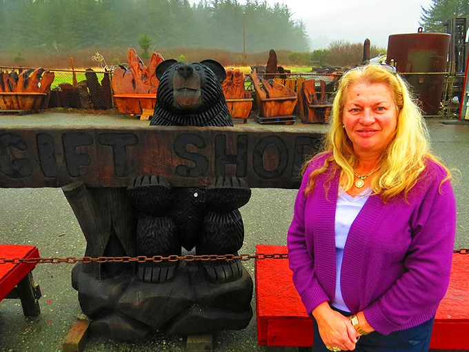 Not pictured: a gift shop. This appears to be an outdoor area near the lighthouse with a carved wooden bear sign.