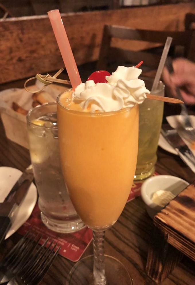 This isn't just a Bellini&mdash;it's sunshine in a glass, topped with whipped cream and a cherry, because sometimes cocktails deserve dessert treatment too.