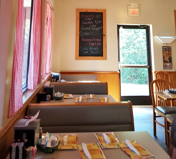 Red checkered curtains frame cozy booths where breakfast dreams come true. Norman Rockwell would feel right at home.