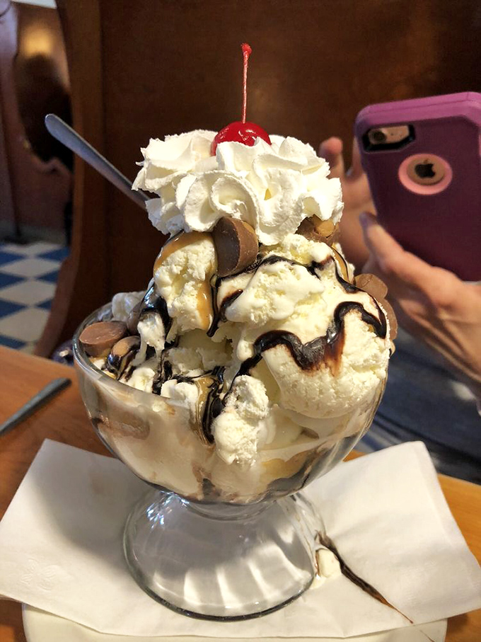 Ice cream architecture at its finest&mdash;layers of sweet engineering topped with a cloud of whipped cream that defies both gravity and restraint.