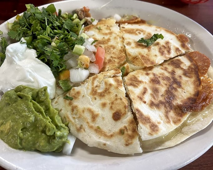 Quesadillas that achieve the golden ratio of crisp exterior to molten interior. That cilantro garnish isn't just pretty &ndash; it's the perfect counterpoint to all that cheese.