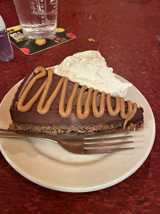 Chocolate tart with caramel drizzle&mdash;proof that geometry and dessert are perfect partners. That whipped cream isn't decoration; it's essential balance to the richness.