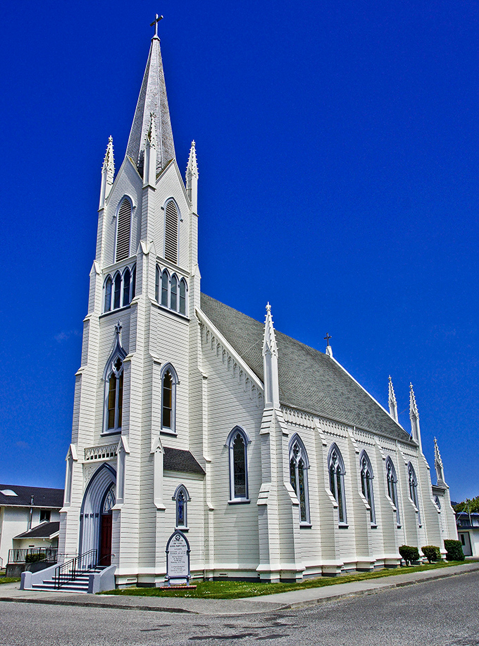 The Church of the Assumption reaches skyward with Gothic precision, a brilliant white beacon against Humboldt County's famous blue skies.