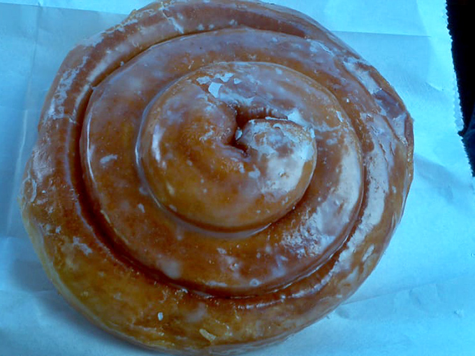 The cinnamon roll donut&mdash;a spiral of happiness with glaze catching light like morning dew on a spider's web.