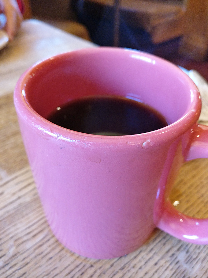The pink coffee mug adds a touch of whimsy to your caffeine ritual. In diners, coffee isn't just a beverage&mdash;it's a constitutional right.