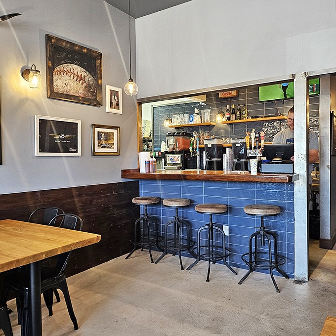 The blue-tiled bar area offers front-row seats to barbecue theater, with vintage artwork providing the perfect backdrop.