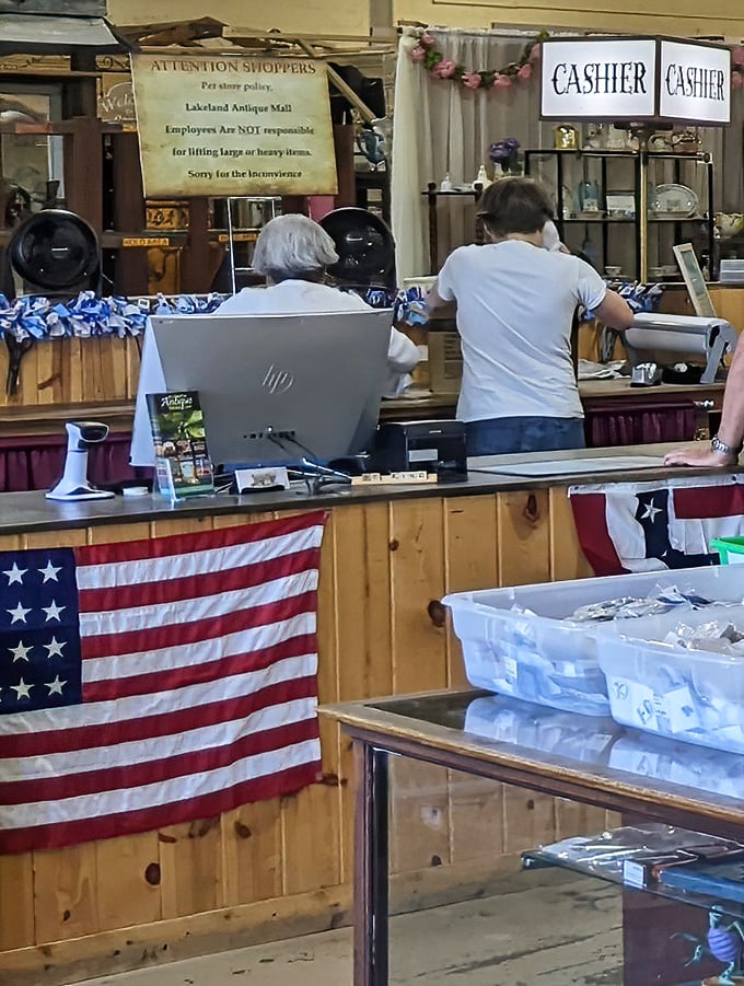 The cashier counter, adorned with American flag bunting, is where treasure hunters complete their quests. Every purchase has a story behind it.