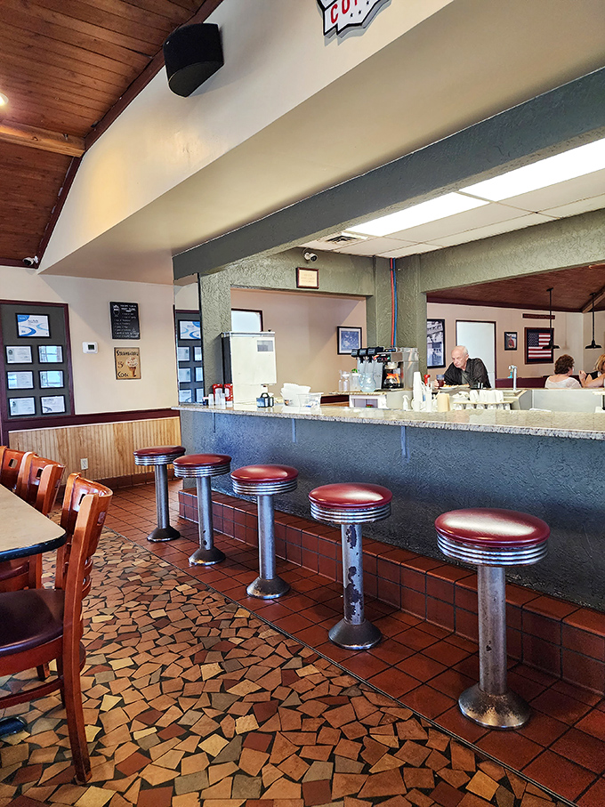 Counter seats where regulars have claimed their spots for years. These red vinyl stools have supported generations of happy diners.