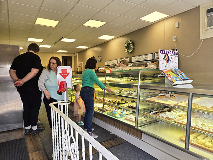 Customers navigate the bakery's offerings with the serious concentration of art collectors at an auction &ndash; each selection a potential masterpiece.