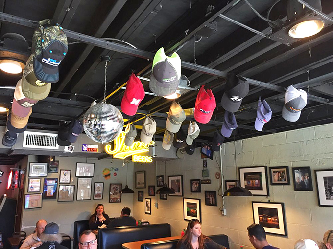 Baseball caps hanging from the ceiling like trophies of meals past. The disco ball adds just enough whimsy to this temple of serious eating.