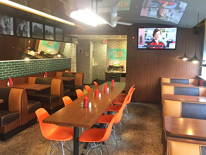 Orange chairs pop against wooden tables like exclamation points in a love letter to casual dining done absolutely right.