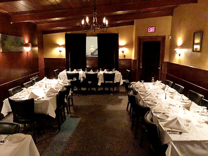 The private dining room stands ready for celebration, where white tablecloths and warm lighting set the stage for memorable toasts and unforgettable meals.
