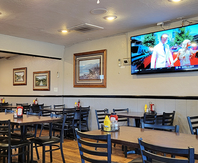 Modern meets traditional in this dining area where mountain landscapes hang on walls while TVs keep you connected to the outside world you're happily ignoring.
