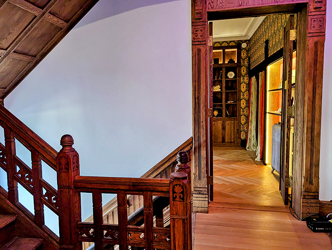 The richly carved wooden staircase and doorway reveal craftsmanship from an era when homes were built to last for centuries.