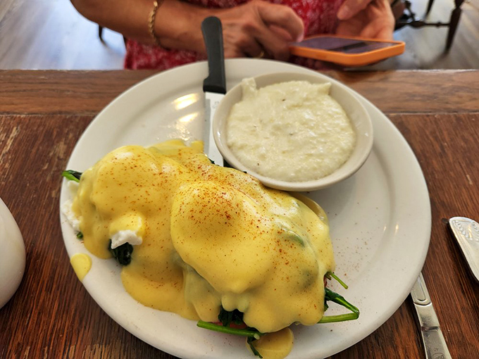Eggs Benedict with hollandaise so yellow it could brighten a rainy day, served with grits that understand their supporting role perfectly.