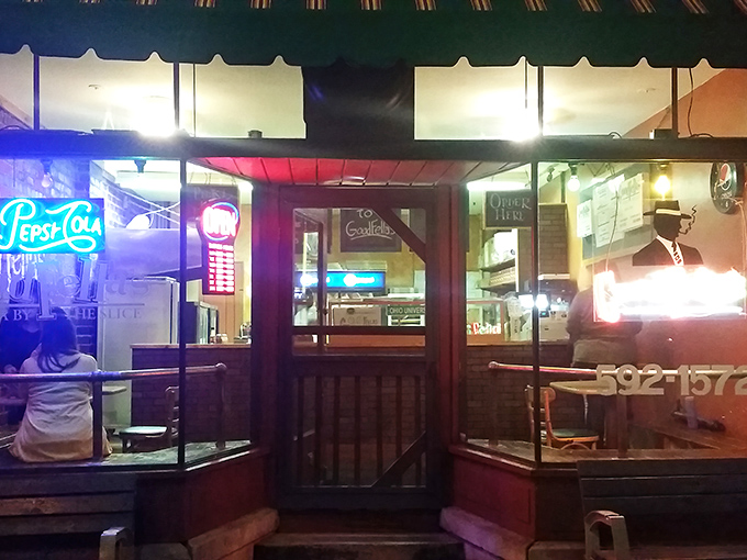 As night falls, the neon Goodfellas sign glows like a lighthouse guiding hungry souls to pizza salvation.