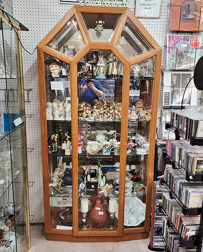 This display case is like a tiny museum of curiosities, where porcelain figurines and vintage mugs compete for your attention.