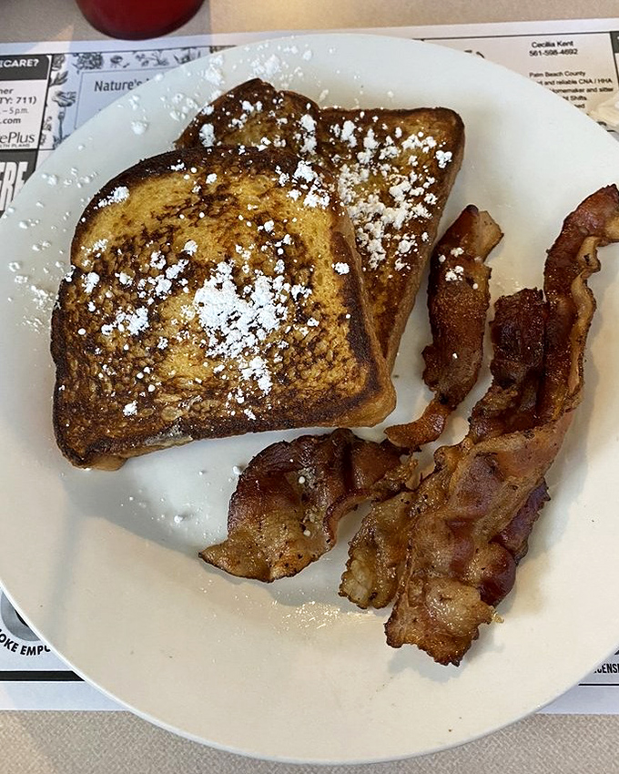 French toast dusted with powdered sugar and served with crispy bacon&mdash;breakfast's perfect sweet and savory romance on a plate.