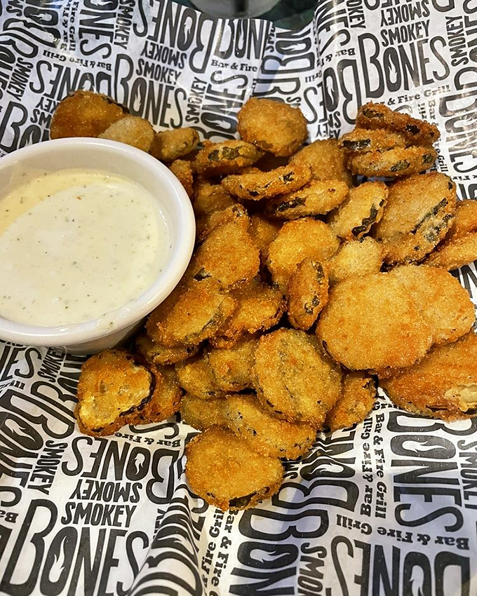 Fried pickles that achieve the impossible balance of crispy exterior and tangy interior &ndash; the unsung heroes of the appetizer world served on branded paper.