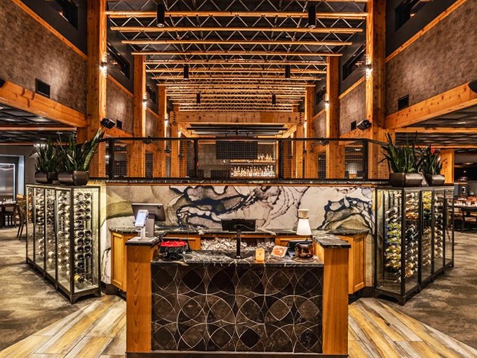 The host station that's seen thousands of "wow" reactions as first-timers walk in. That stone and wood combination isn't just design—it's a promise of what's to come.