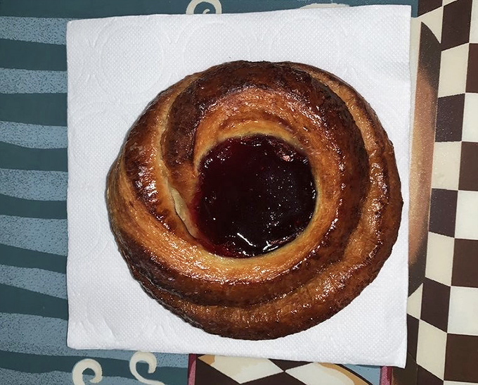 This danish isn't just breakfast—it's edible art. The spiral design with that jewel-like center of fruit preserves belongs in the Louvre of pastries.