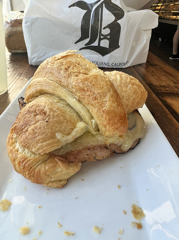 This ham and cheese croissant isn't just breakfast, it's performance art &ndash; layers of pastry embracing savory fillings in perfect harmony.