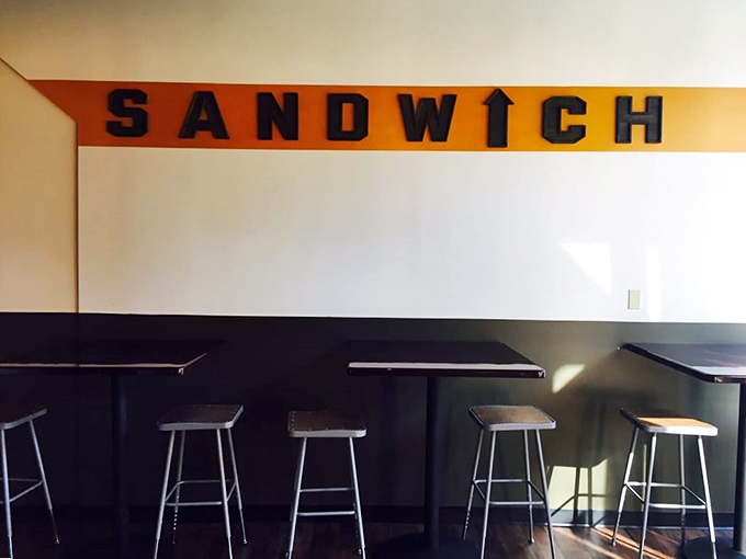 High-top seating beneath the commanding "SANDWICH" sign – a temple of simplicity where worshippers gather to pay homage to bread-based perfection.