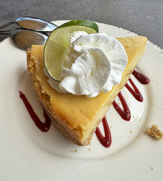 Key lime pie that hits that perfect sweet-tart balance like a culinary tightrope walker. That whipped cream dollop is the chef's way of saying "You're welcome."
