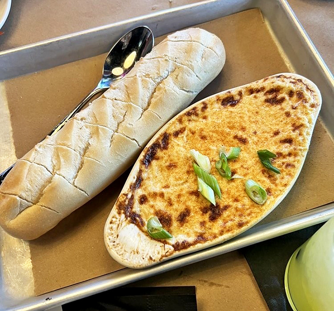 Lobster dip with the golden-brown crust of your dreams, served with bread that's clearly been working out for this very moment.