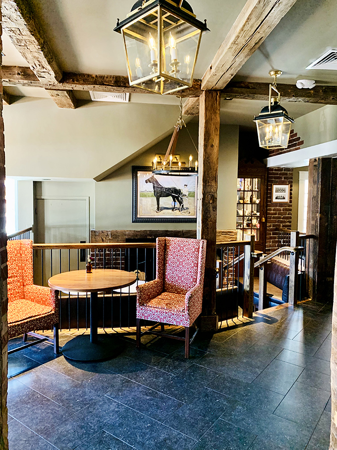Exposed beams, lantern lighting, and patterned chairs create an upstairs lounge that feels both rustic and refined&mdash;the perfect perch.