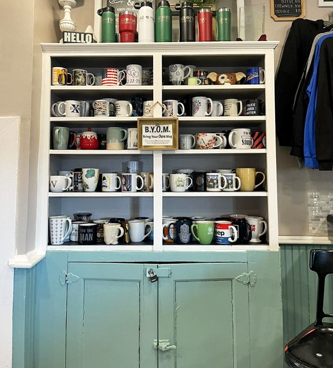 The mug wall&mdash;where coffee vessels come to retire and tell tales of conversations past. Note the "B.Y.O.M." sign!