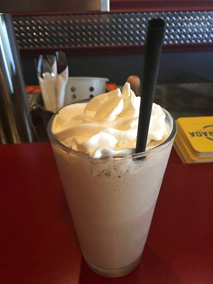 This isn't just a milkshake—it's a cloud of vanilla bliss topped with whipped cream. The straw is merely a delivery system for pure joy.