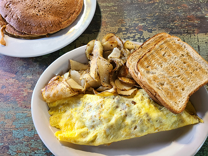 An omelet so fluffy it could moonlight as a pillow, paired with potatoes that actually taste like potatoes.