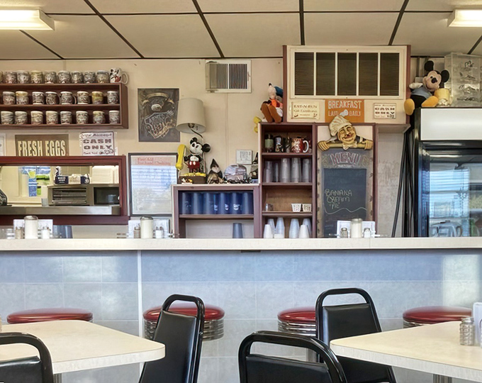 Behind this counter, breakfast magic happens without fanfare. Those coffee mugs lined up like soldiers ready for the morning rush.